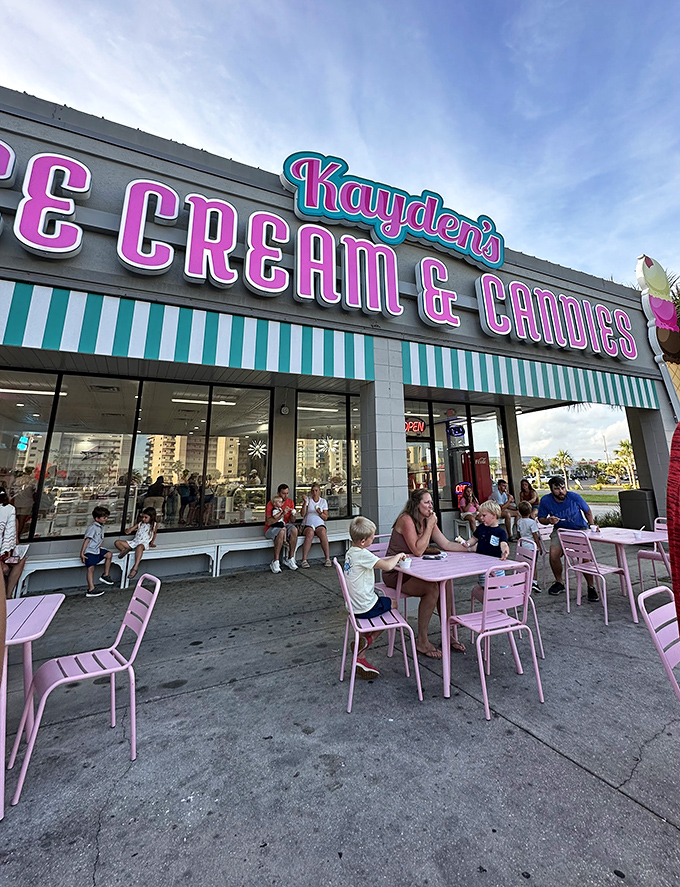 Pink chairs under turquoise awnings create the perfect stage for the timeless performance of "Human Enjoys Ice Cream."