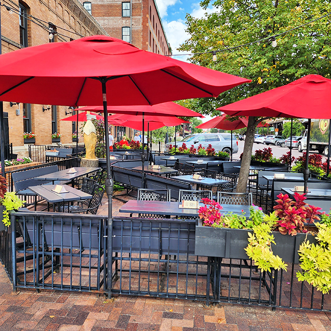 Outdoor dining under vibrant red umbrellas, where summer breezes and Old Market charm enhance every bite and sip.