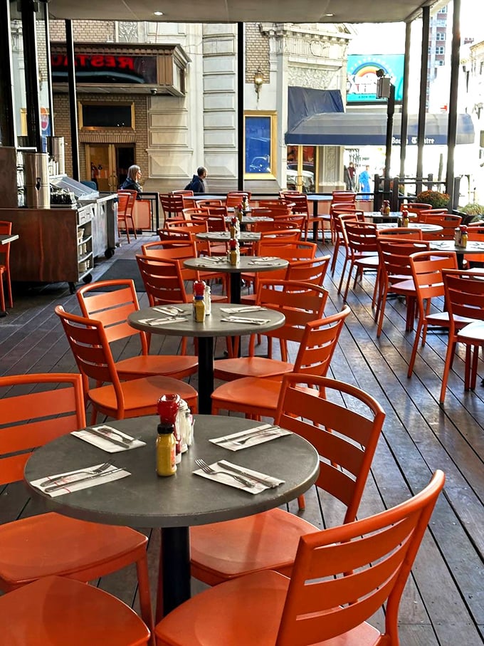 The outdoor seating at Junior's: where people-watching becomes an Olympic sport and orange chairs pop against the city backdrop.