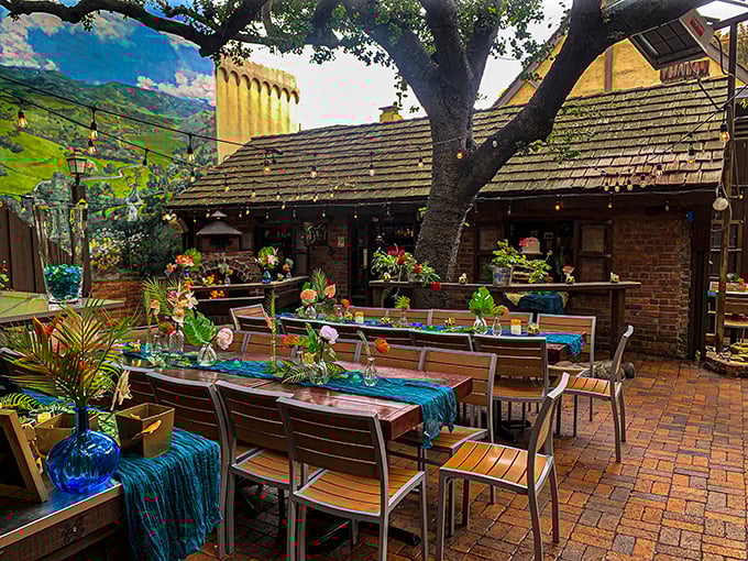 The patio doesn't just offer outdoor seating; it presents a California dining fantasy complete with dappled sunlight filtering through ancient oak branches.