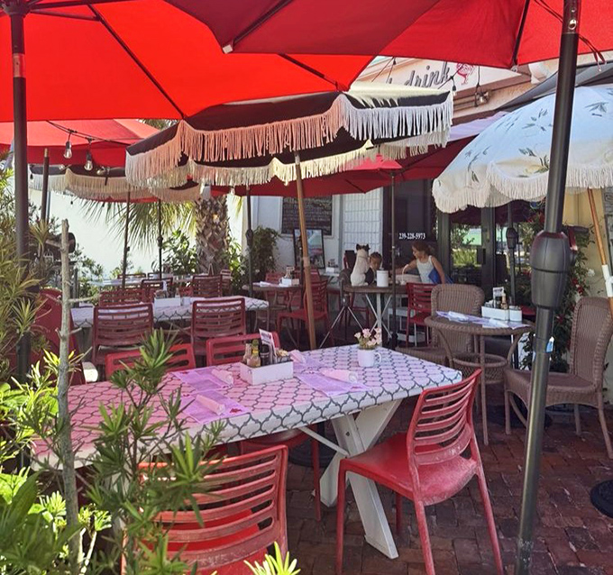 The outdoor patio, draped with fringed umbrellas and surrounded by greenery, turns everyday breakfast into a mini Florida vacation.