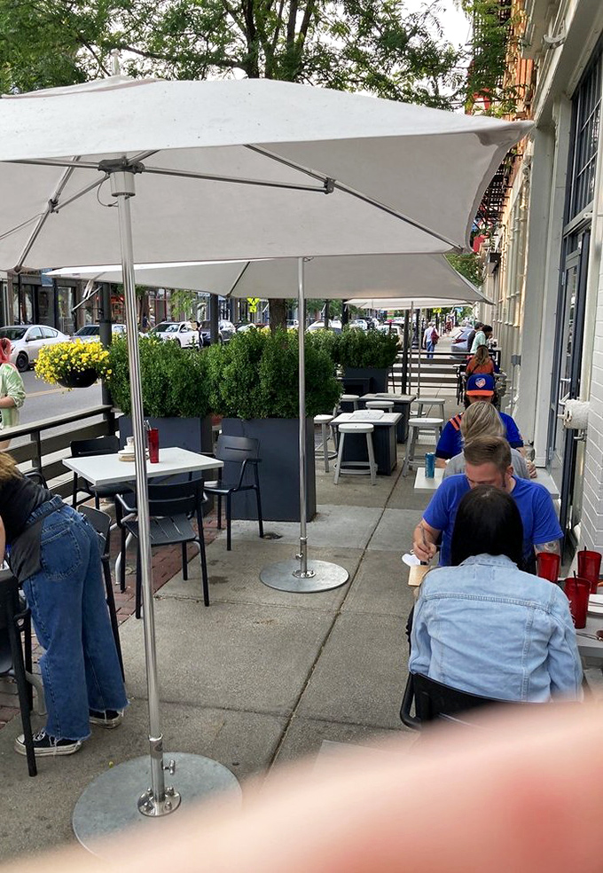 Al fresco dining under white umbrellas, where the only thing better than people-watching is watching your server approach with food.