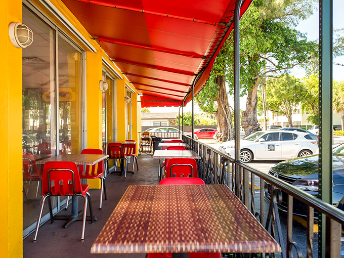 Outdoor seating under a cherry-red awning offers the perfect spot to contemplate life's big questions, like "Should I order seconds?" 
