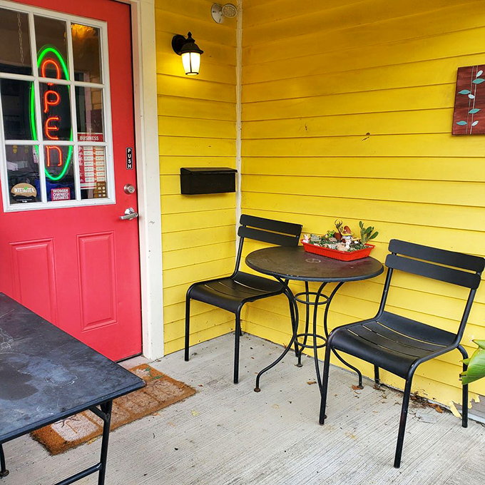 The front porch seating area where time slows down just enough to savor every bite. That yellow wall and red door combo is Kentucky's answer to European caf&eacute; culture.