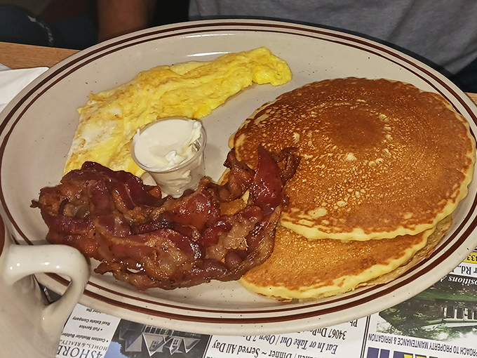 Breakfast of champions: golden pancakes with the perfect circumference, eggs with sunshine-yellow yolks, and bacon that's achieved crispy nirvana. Morning glory on a plate.