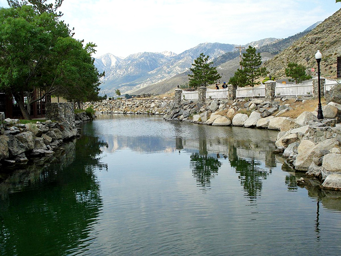 The peaceful pond reflects the majestic mountains beyond &ndash; nature's version of a double feature that never gets old.