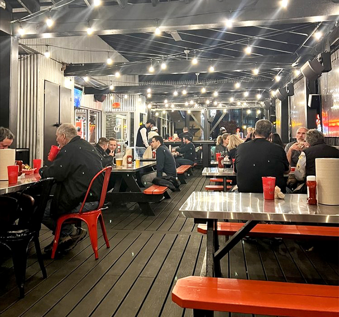 The patio at dusk, where string lights twinkle above tables of people experiencing both pleasure and pain in equal measure.