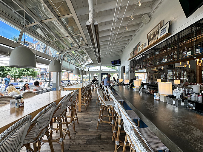 Sunlight floods the bar area where wooden stools await patrons seeking craft cocktails with a side of people-watching – an indoor-outdoor masterpiece.