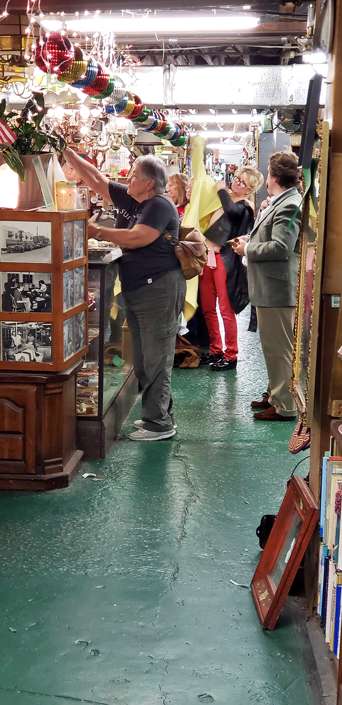 The thrill of the hunt! Fellow treasure seekers examine potential purchases with the focused concentration of archaeologists unearthing ancient artifacts.