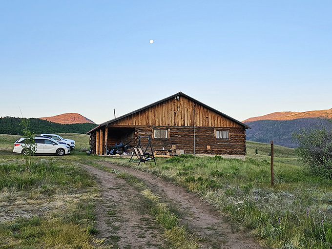 Log cabin simplicity meets mountain majesty at dusk, when even the moon shows up early to admire the view.