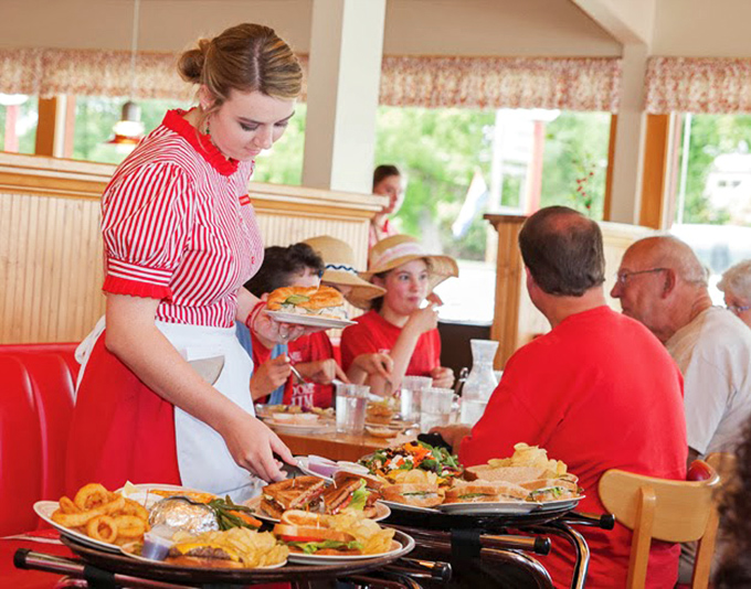 The Cherry Hut's servers, dressed in classic red and white, deliver plates with the confidence of people who know they're carrying edible happiness.