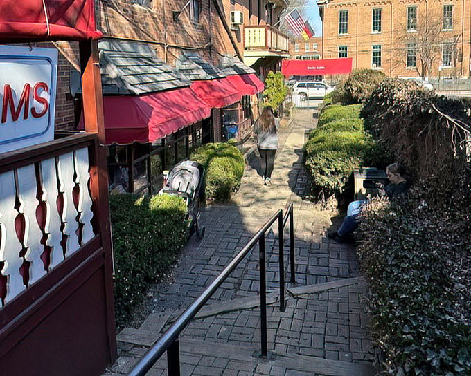 The winding brick pathway feels like something from a storybook itself. Each step brings you closer to literary treasures hiding behind those red awnings.