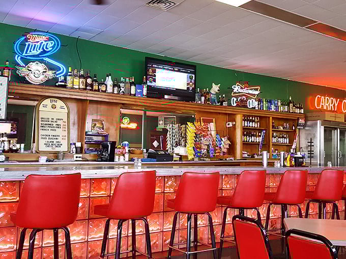 The bar area glows with neon promises of cold beer and good times. Those red stools have heard more Indianapolis stories than any therapist in town.