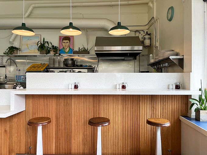 The counter's warm wood paneling and minimalist stools create that perfect "neighborhood joint" vibe where regulars and first-timers feel equally at home.