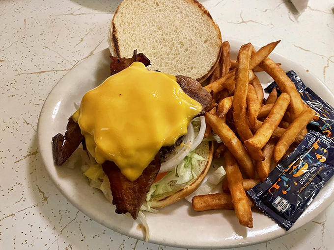This isn't just a burger &ndash; it's a hand-formed testament to simplicity, with melted American cheese cascading down the sides like a yellow waterfall.