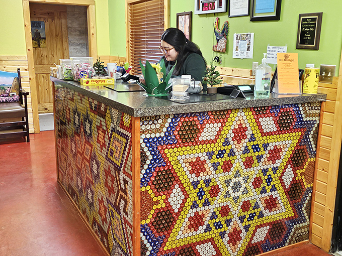 The front counter showcases a dazzling bottle cap mosaic that deserves its own museum exhibit. Functional art that welcomes hungry patrons.