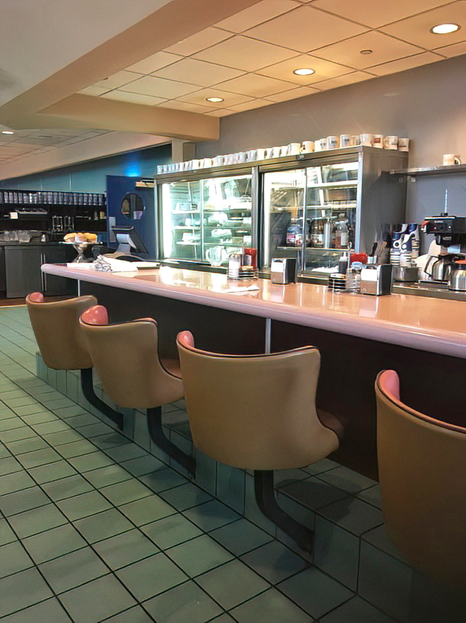 The counter area&mdash;where diner magic happens. Those pink swivel seats have probably witnessed more town gossip than the local barber shop. 