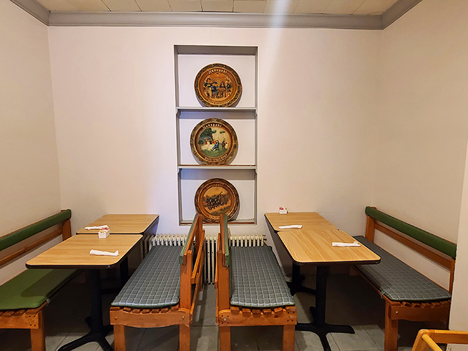 This cozy booth section offers a quieter corner for conversation, with decorative plates that hint at the area's cultural roots.
