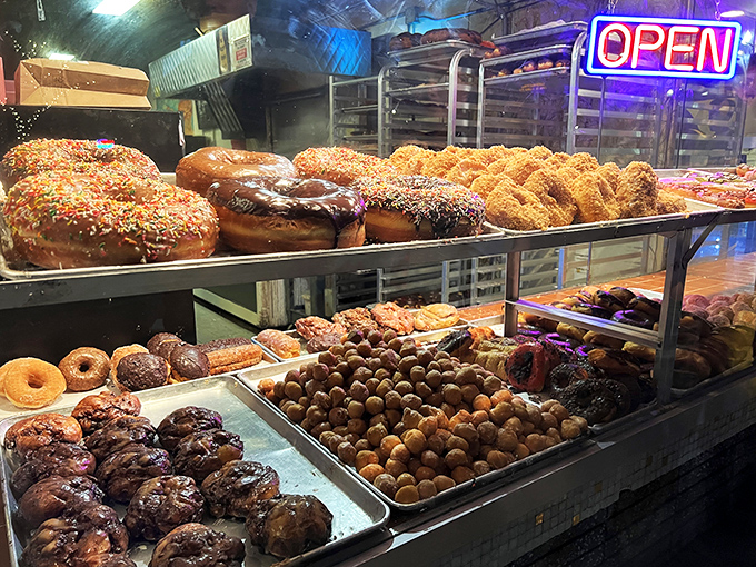 The display case glows like a jewelry store, showcasing edible gems that sparkle under fluorescent lights.