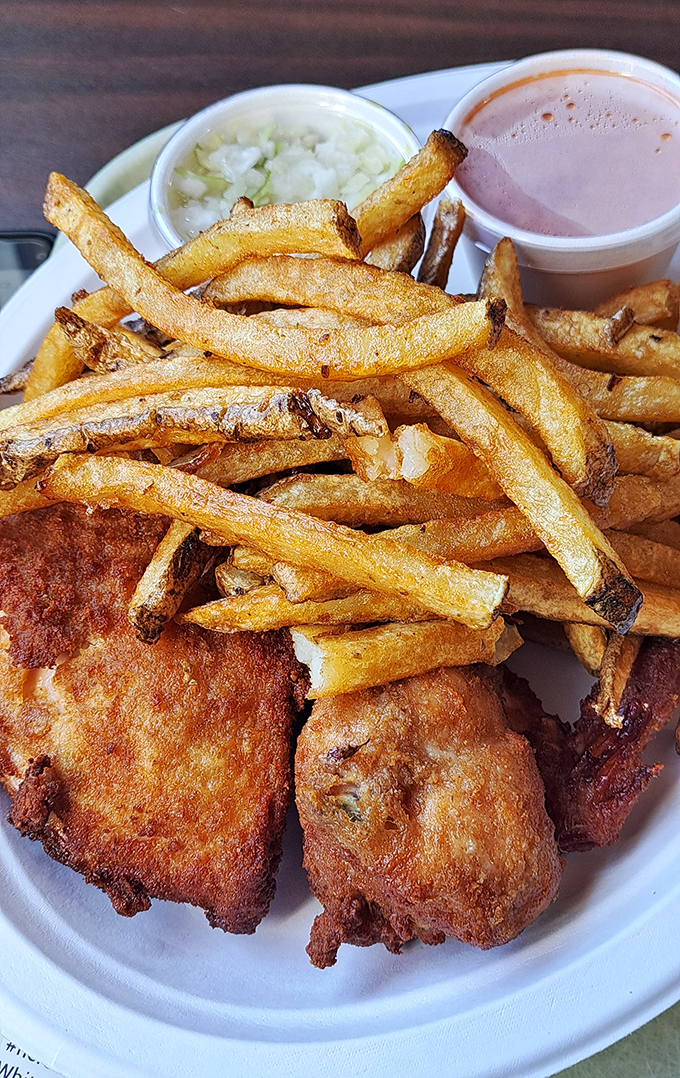 Comfort food geometry: golden rectangles of fries, circular pools of sides, and irregular chunks of perfectly fried chicken creating a plate of pure joy.