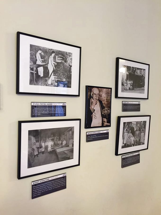 A wall of memories captures generations of pretzel craftsmanship. Black and white photos preserve the hands that twisted history.