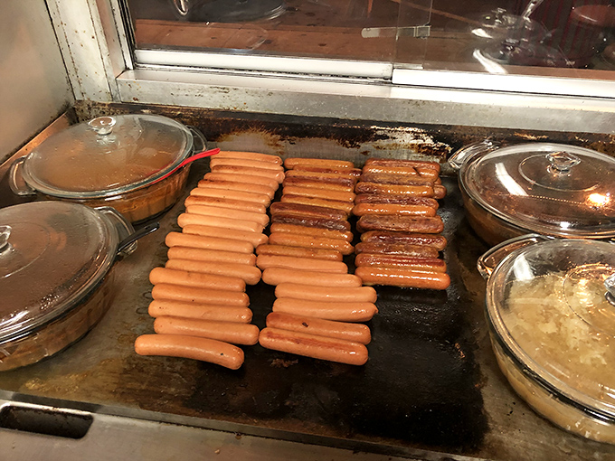Hot dogs in formation, sizzling on the flat-top like a delicious army preparing for the lunch rush battle ahead.