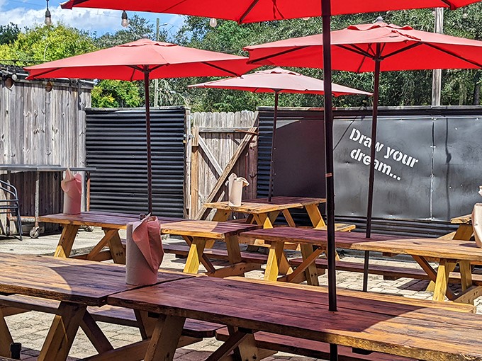 Red umbrellas shade wooden picnic tables in an outdoor space that practically begs you to linger over one more bite.