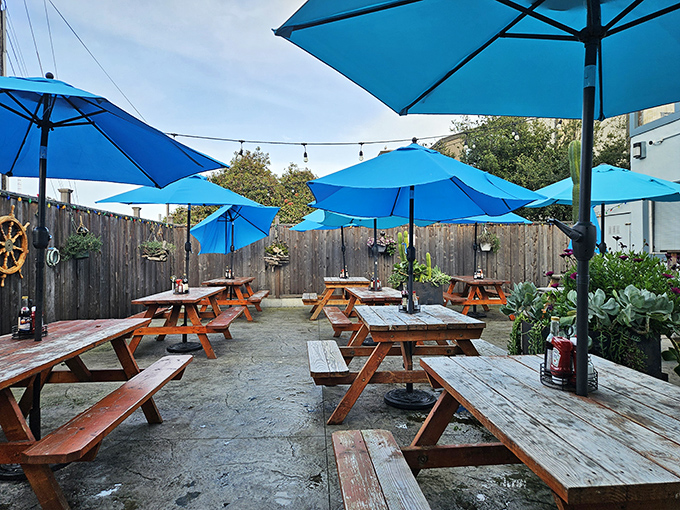 The outdoor seating area, where blue umbrellas mirror the sky and picnic tables invite you to get gloriously messy with your seafood feast.
