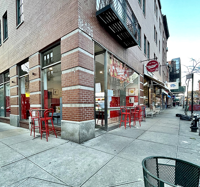 The corner location with its bright red accents serves as both landmark and temptation&mdash;a siren call to cheese lovers strolling through Greenwich Village.