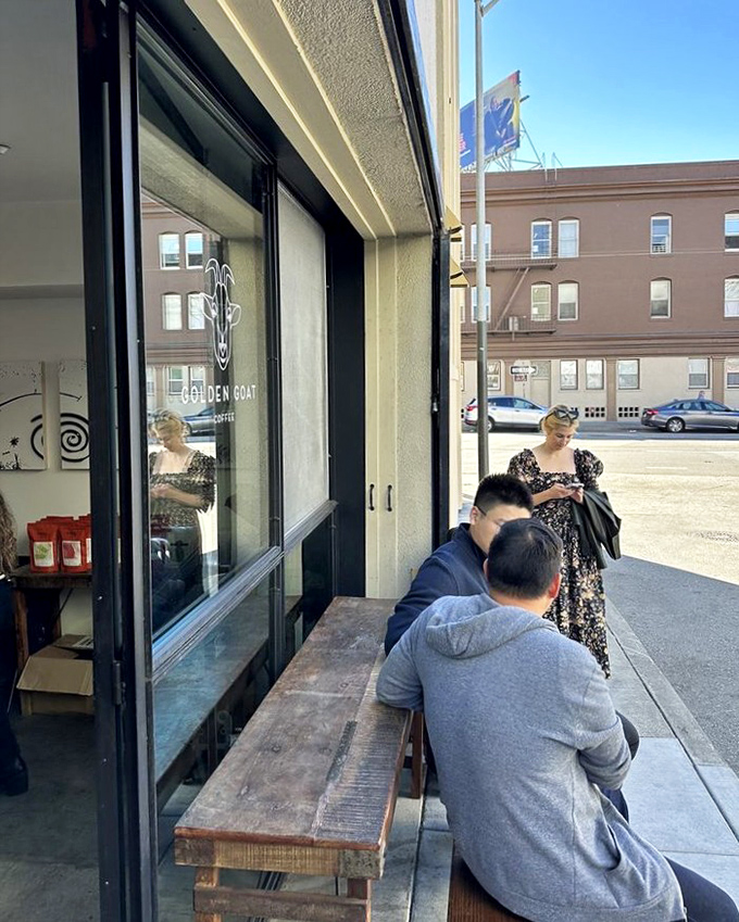 The outdoor bench serves as both waiting area and community hub, where strangers become temporary neighbors united by the pursuit of exceptional coffee.