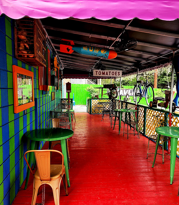 The outdoor patio continues the color explosion, with a "TOMATOES" sign reminding you that amid all this whimsy, real food is still the star.