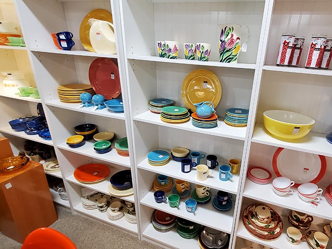 A rainbow of Fiestaware and vintage dishes beckons from white shelves—instant nostalgia for anyone who ever sat at grandma's Sunday dinner table.