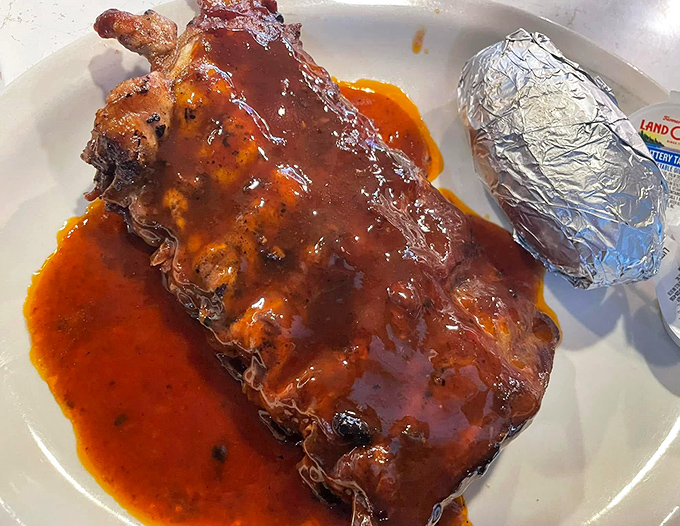 Ribs so tender and sauce-lacquered they make you forget about table manners. That baked potato in foil is just along for the ride.