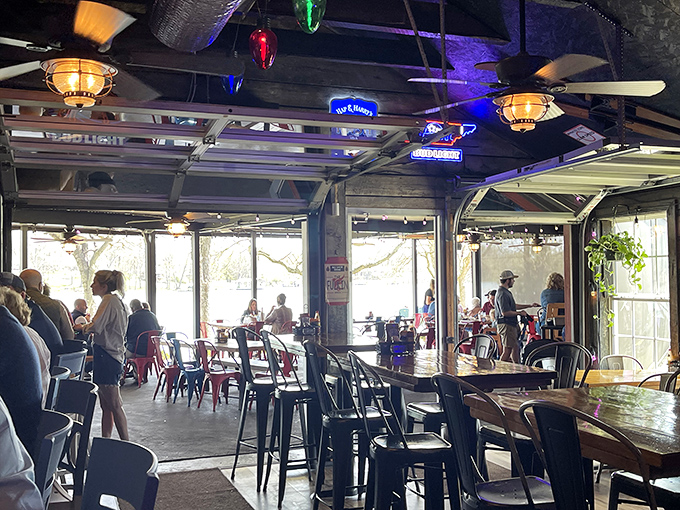 The dining room buzzes with conversation as garage doors frame the outdoor view, creating that perfect "am I inside or outside?" dining confusion.