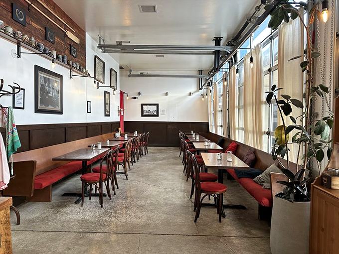 The dining room balances European caf&eacute; charm with Portland's laid-back vibe&mdash;red cushions add pops of color against the wood-paneled warmth.