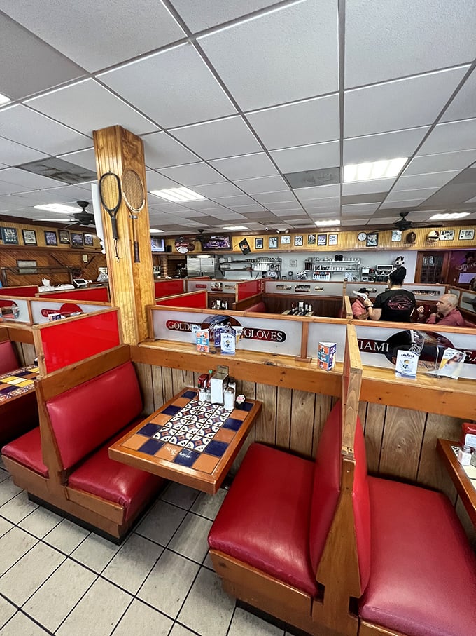 Wooden booths with red vinyl seating – where strangers become neighbors and everyone's united by the universal language of good food.