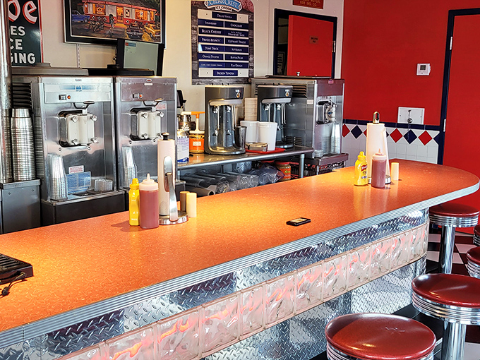The command center where milkshake magic happens. Orange countertops and stainless steel machines stand ready to fulfill your most decadent dairy dreams.