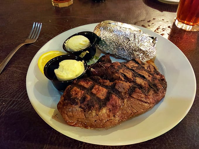 A steak with perfect grill marks that says, "Yes, I've been cooked by someone who respects beef." The foil-wrapped potato agrees.
