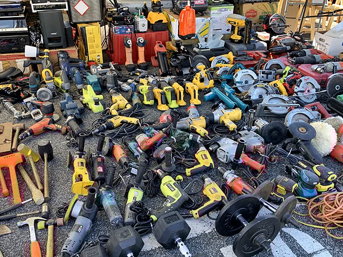 Power tools scattered like a handyman's dream garage sale where every project becomes suddenly possible again.