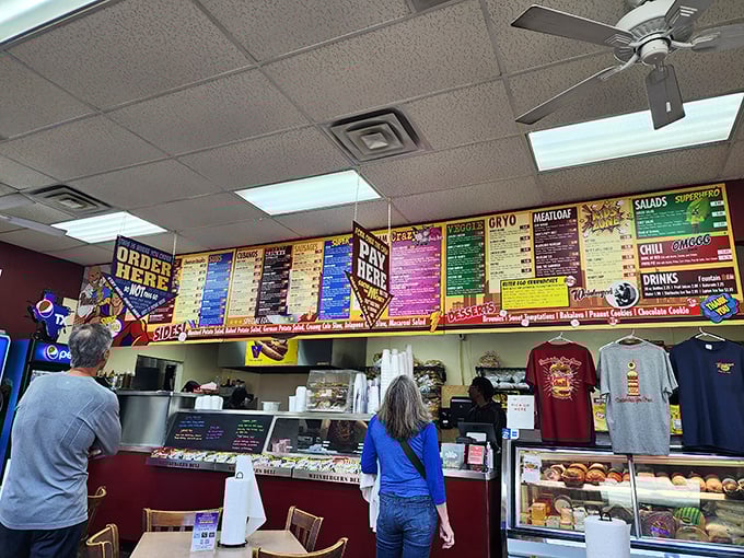 The bustling counter where sandwich dreams come true. That colorful menu board is like the Sistine Chapel ceiling of deli options.