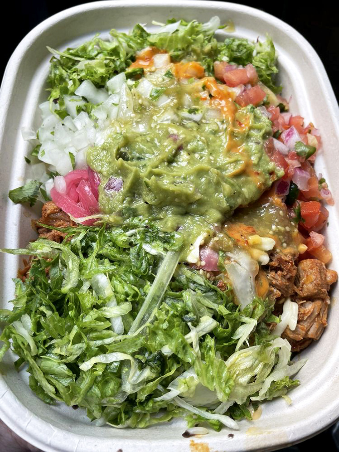 A bowl where every ingredient knows its role yet plays well with others. The guacamole takes center stage while lettuce provides the perfect supporting cast.