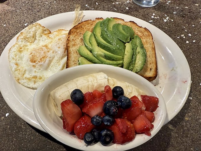 A symphony of colors and nutrients: fresh berries, avocado, and a sunny-side-up egg create breakfast's answer to balanced perfection.
