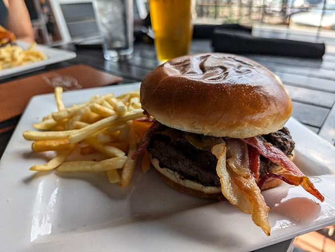 A burger that requires both hands and a strategy &ndash; note the bacon peeking out like it's trying to make new friends.