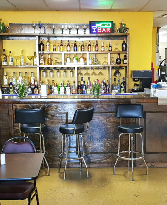 The bar area isn't just serving drinks&mdash;it's offering liquid vacation vibes. Those bottles stand at attention, ready for your celebration.