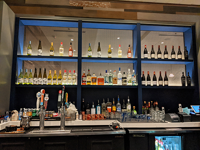 The bar's impressive spirits collection promises creative cocktails to complement your seafood feast. Blue backlighting adds to the underwater ambiance.