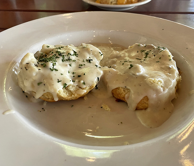 Biscuits swimming in creamy gravy—a Southern baptism that transforms ordinary mornings into something worth setting an alarm for.