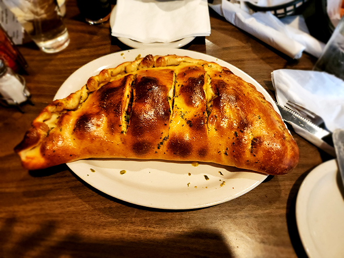 This calzone isn't just a meal &ndash; it's a golden-brown life raft of cheese and dough sailing on a sea of marinara possibilities.