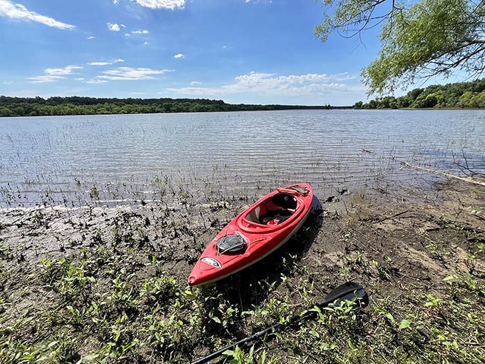 The red kayak waits patiently for its next adventure. Water exploration vehicle, sunset viewing platform, and upper-body workout all in one.