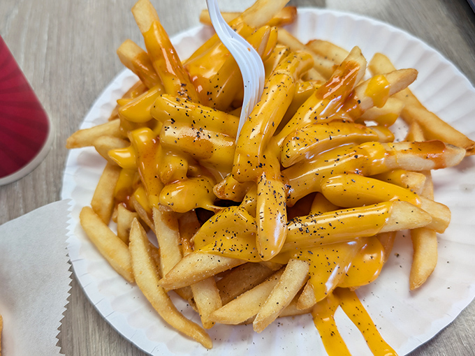 Cheese fries that don't apologize for being exactly what they are: a glorious, melty masterpiece sprinkled with black pepper for sophistication. 