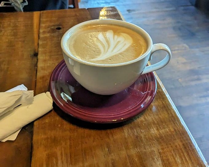 This isn't just coffee&mdash;it's a cinnamon bun latte artwork, where barista skill meets comfort-in-a-cup on a rustic wooden table.